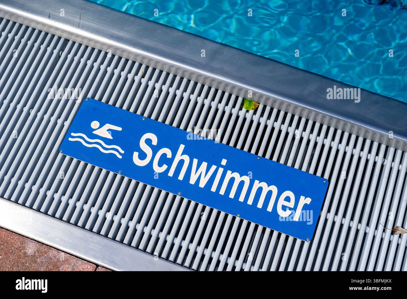 Swimmer sign written in blue letters on the edge of a public swimming ...