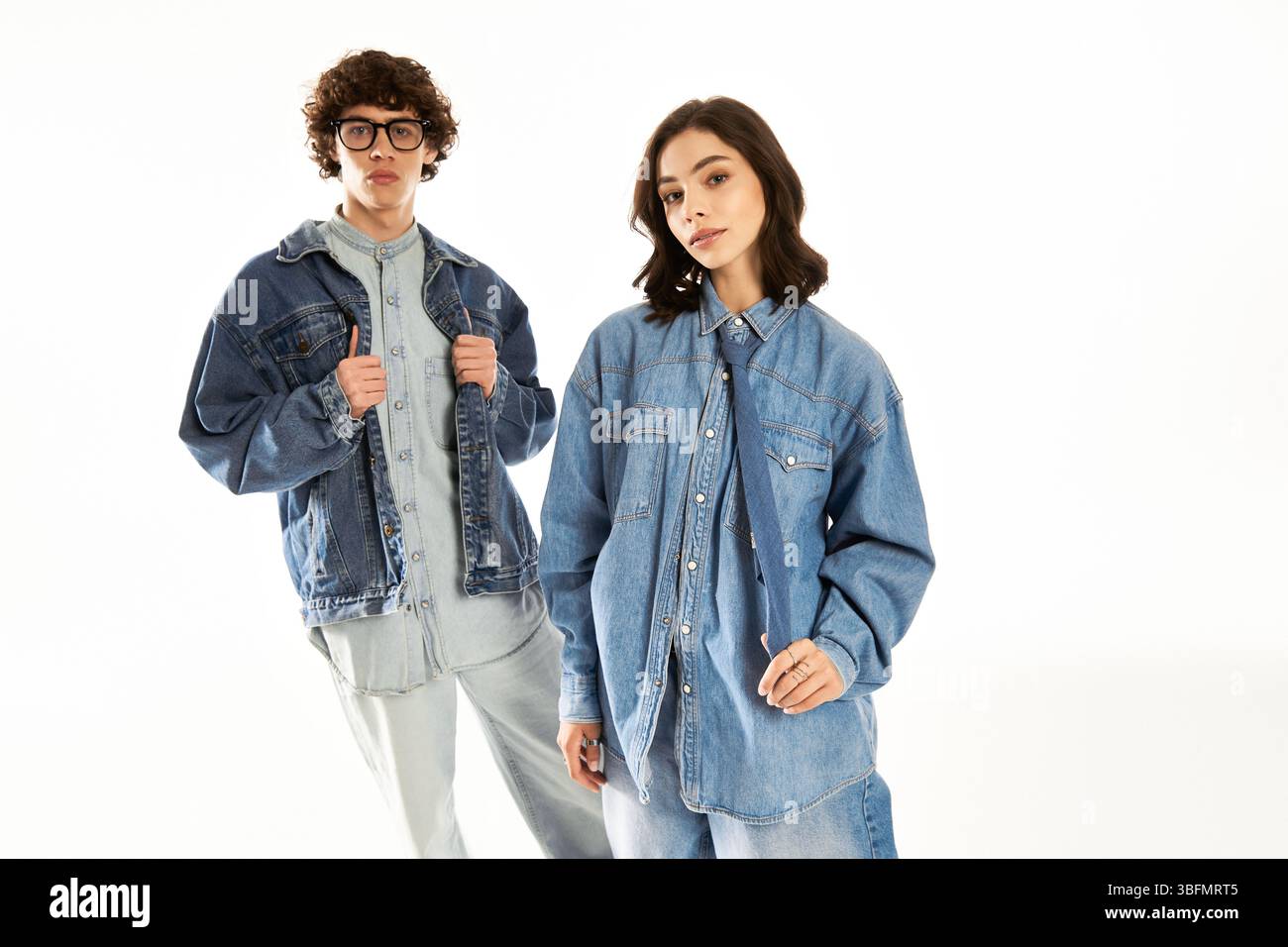 Stylish man and woman express love while posing in matching denim ...