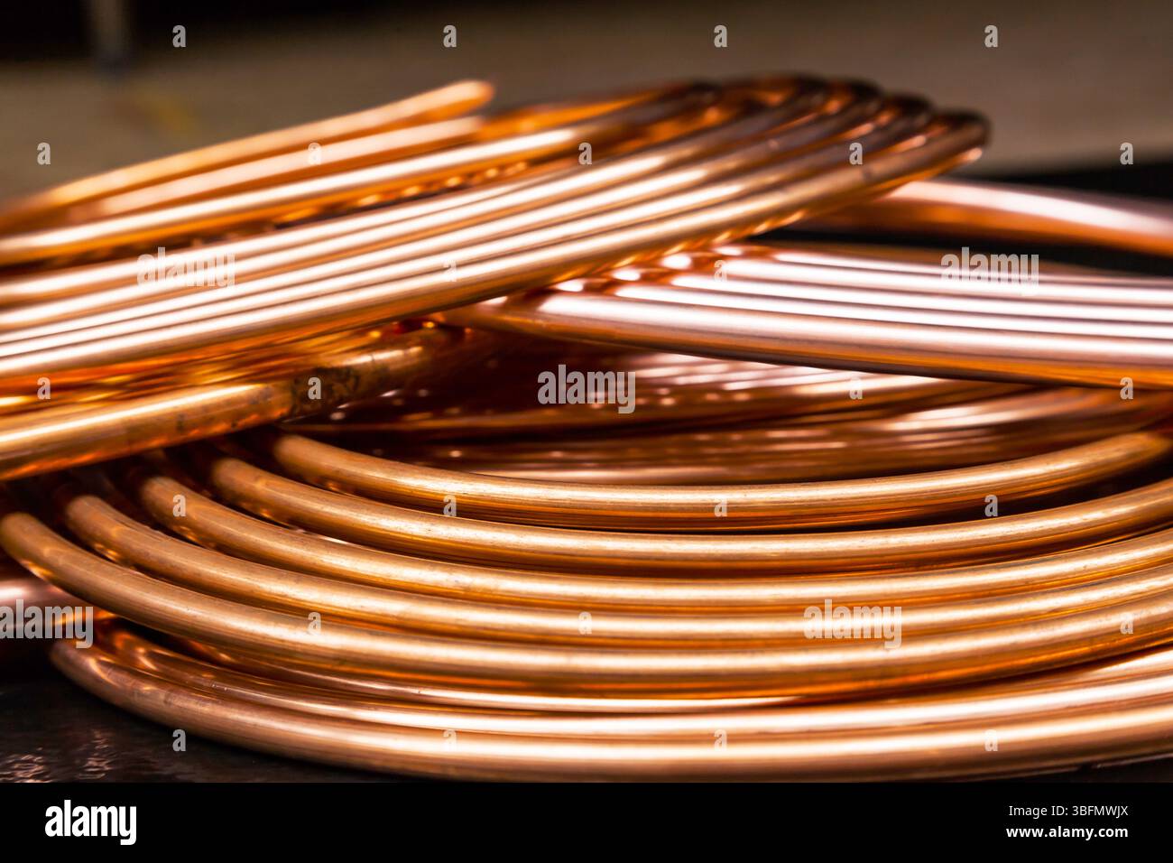 Twisted new copper tubes on a black background Stock Photo - Alamy
