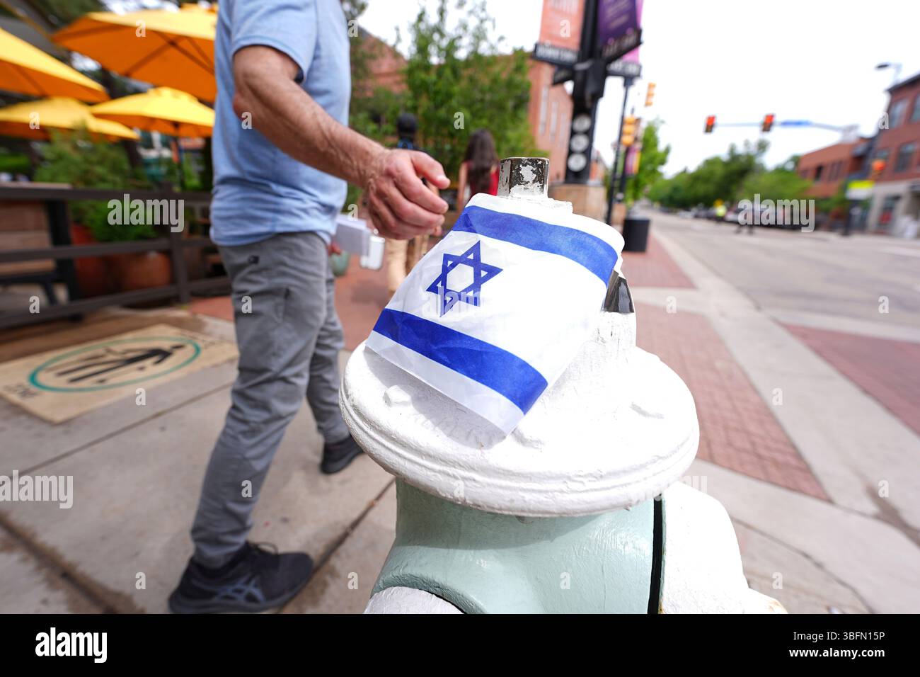 A passer-by touches the flag of Israel taped on to the top of a bollard ...