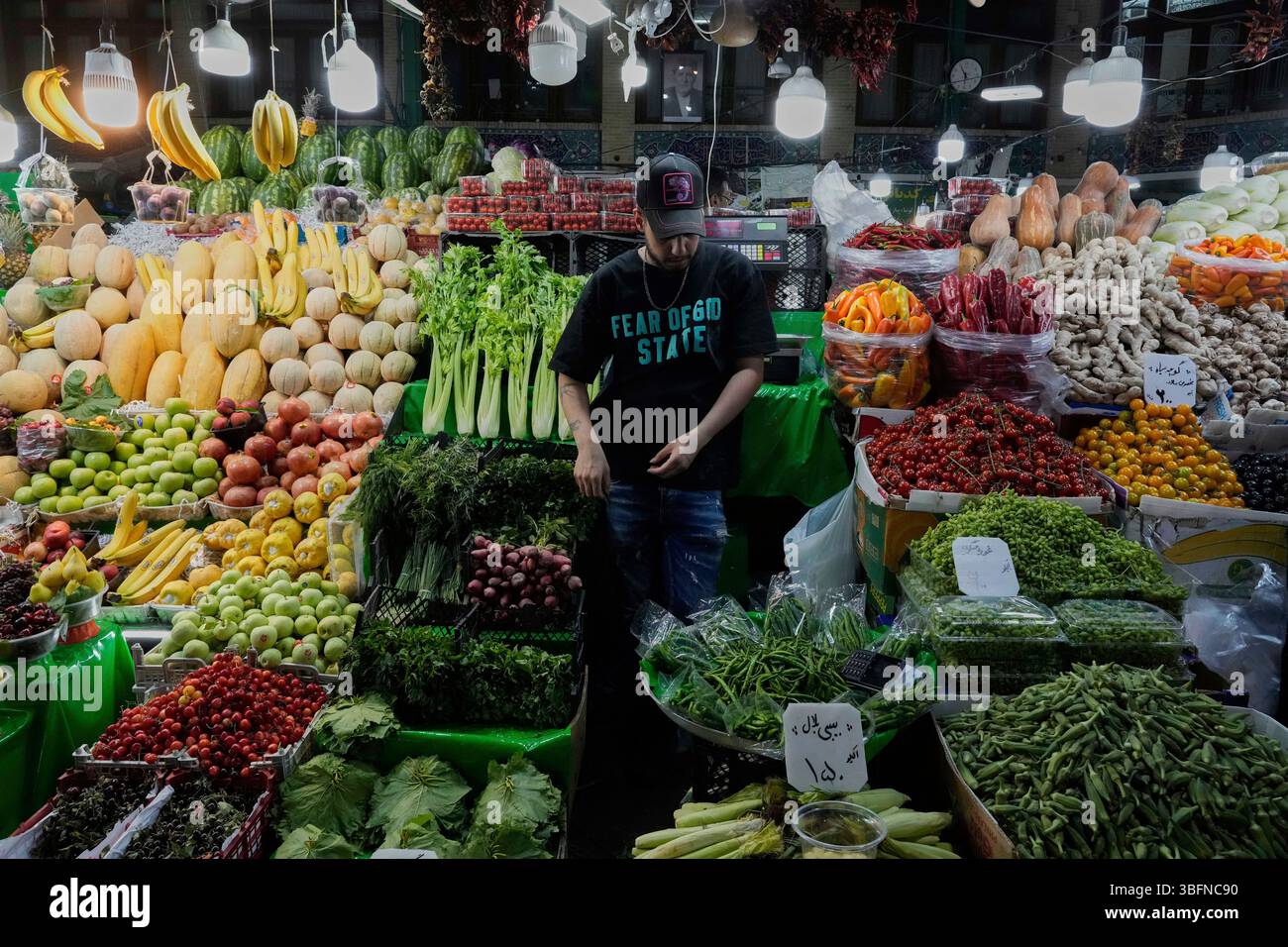 A fruit and vegetable vendor waits for customers in Tajrish traditional ...