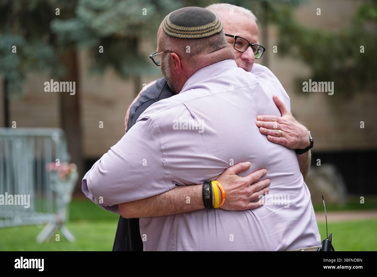 Rabbi Fred Greene of Congregation Har Hashem, front, hugs a man outside ...
