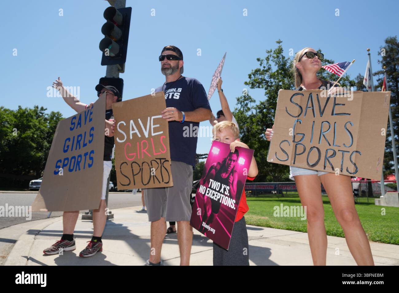 People hold Save Girls Sports signs in protest of transgender athlete ...