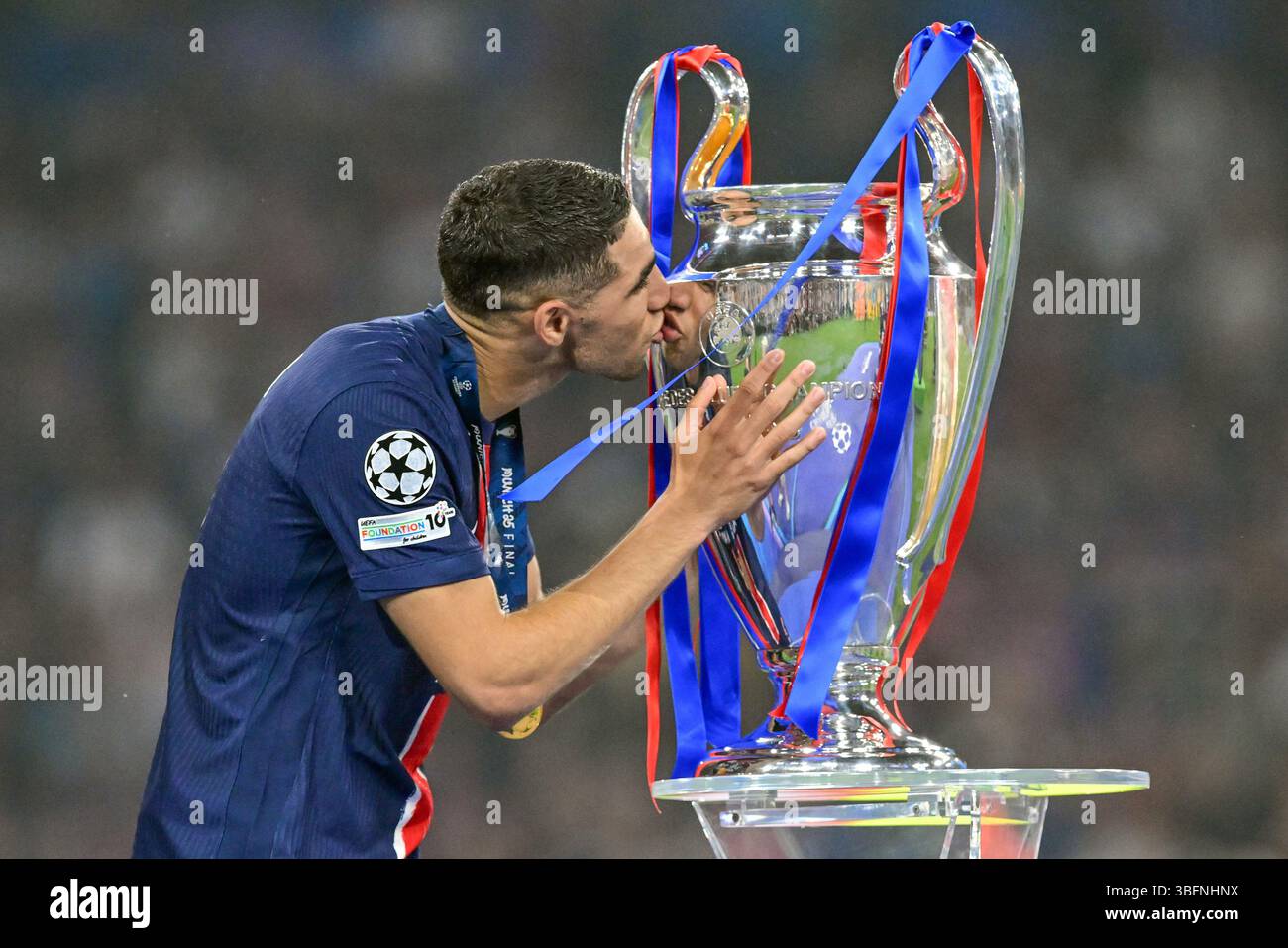 Munich, Germany. 31st, May 2025. Achraf Hakimi of Paris Saint-Germain is kissing the trophy at ...