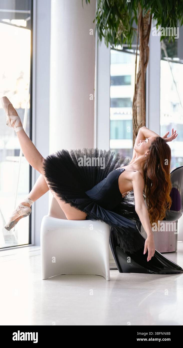 Ballet dancer in dramatic reclining pose on modern white chair Stock ...