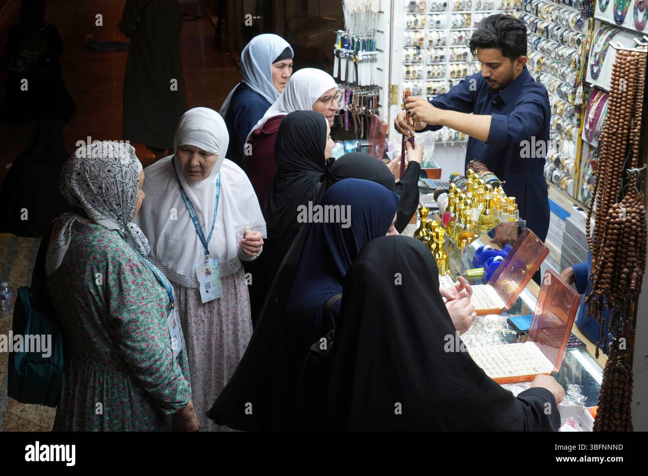 Muslim pilgrims buy souvenirs at a shop outside the Grand Mosque ...