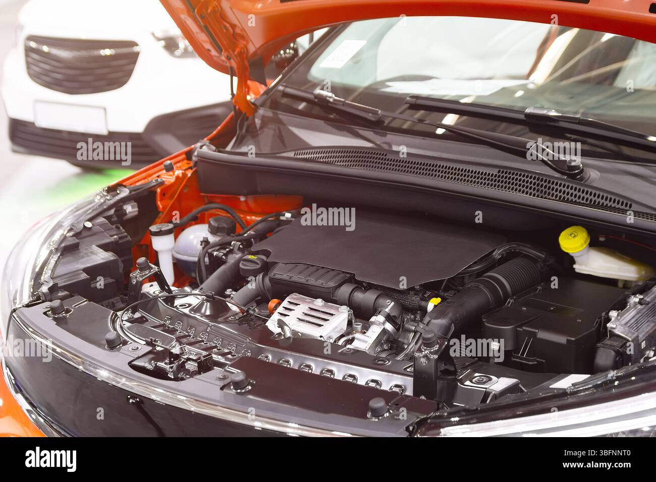 Open hood of a new car revealing engine in auto shop. Transport Stock ...