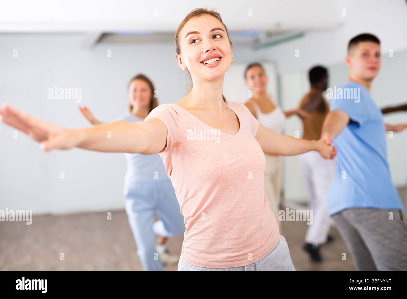 Smiling young adult couples dancing together in pairs and practicing ...