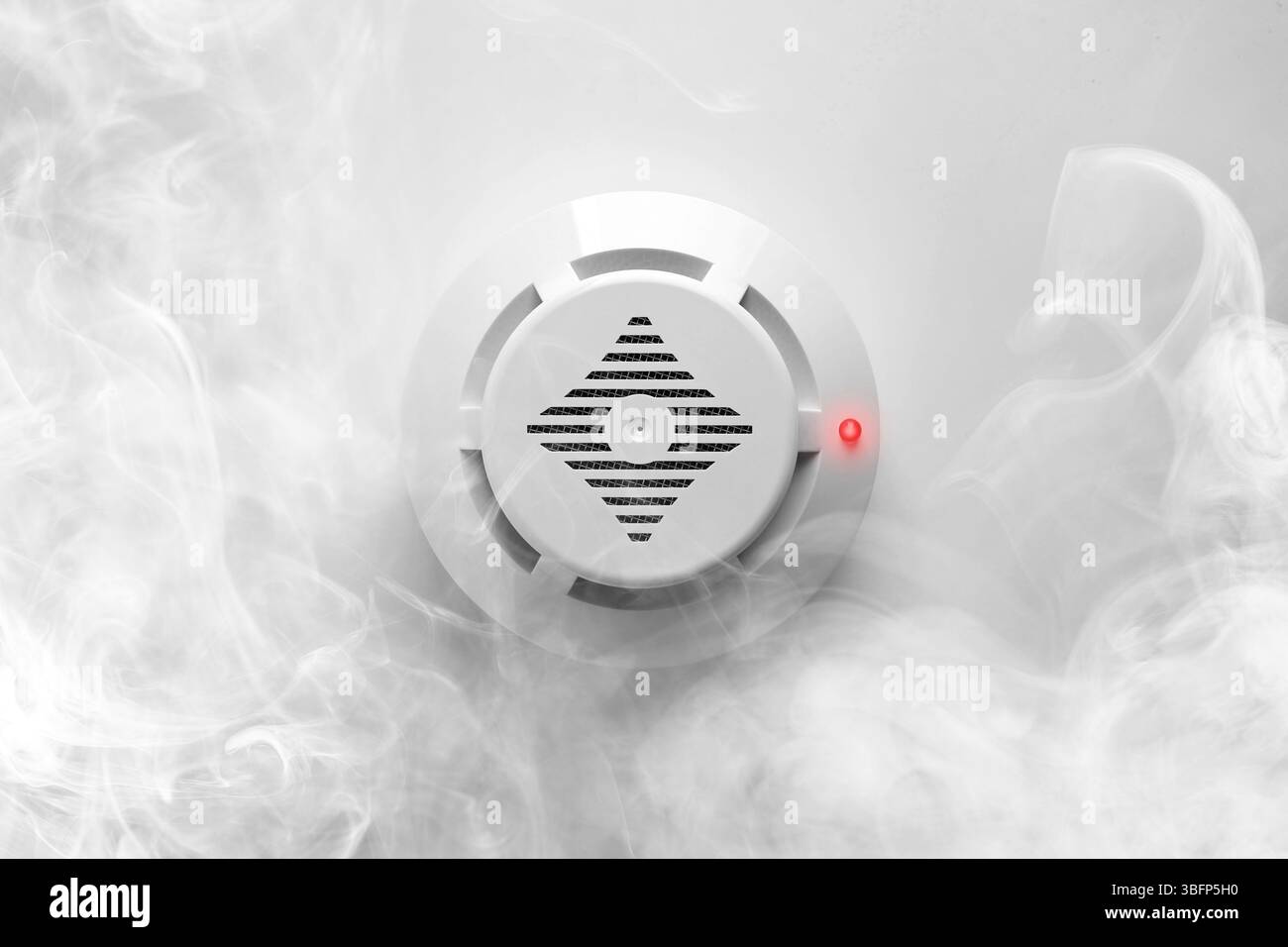 Fire alarm system detector on ceiling triggered by smoke, bottom view ...