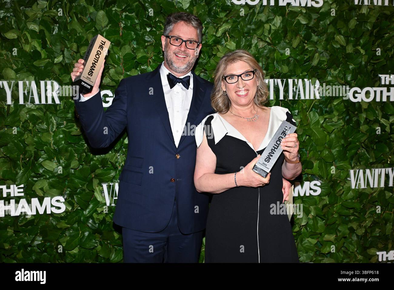 Frank Evers, left, and Lauren Greenfield pose in the winner's room with the award for ...