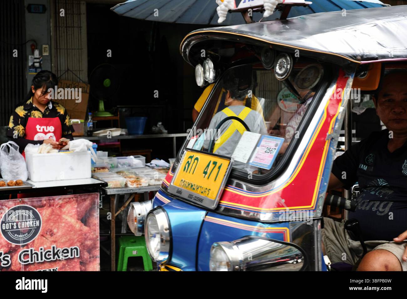 A tuk tuk parked in front of a street food stall at Soi 20, Silom, a ...
