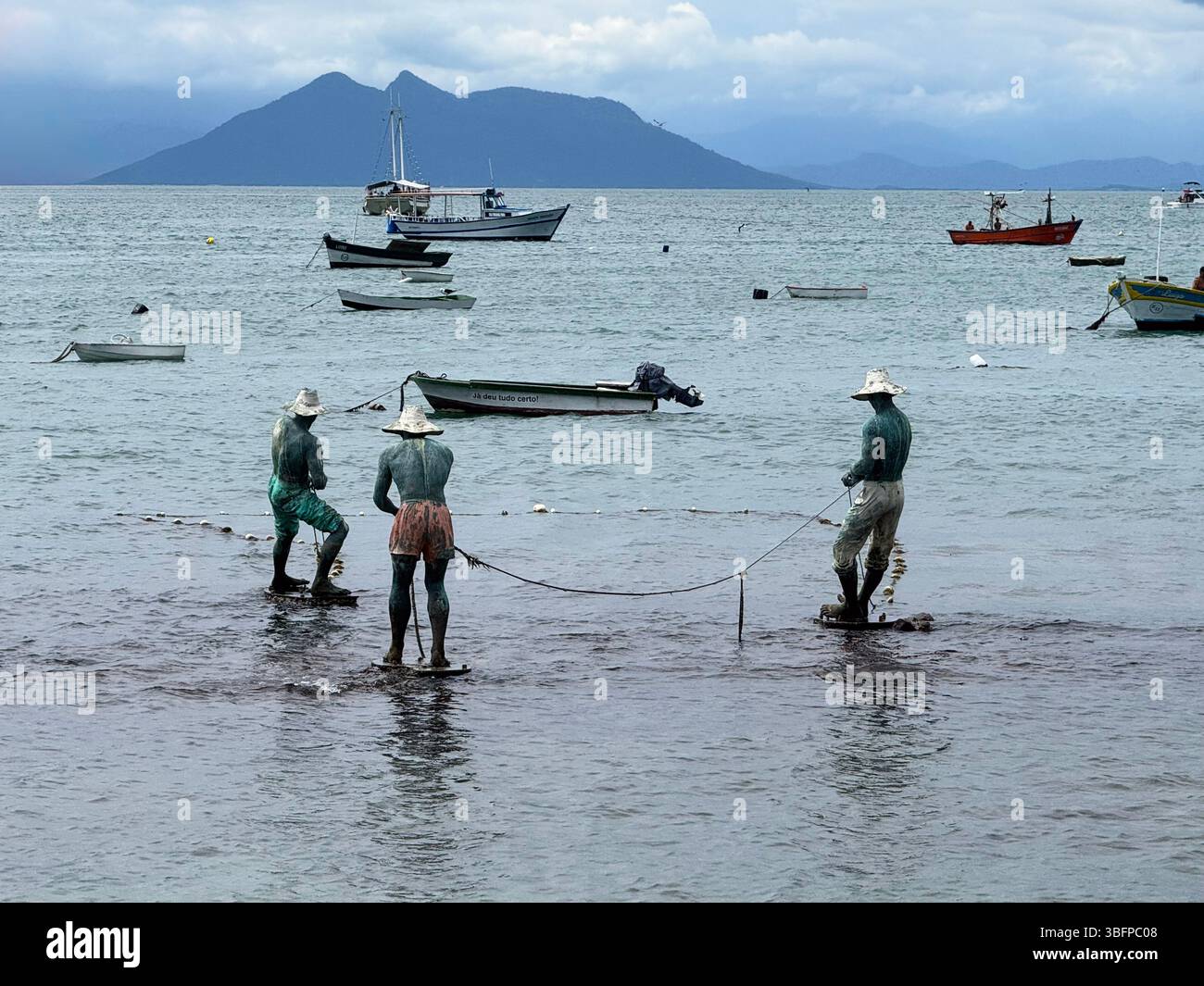 Statues of fishermen pulling nets from the sea in Búzios, Rio de ...
