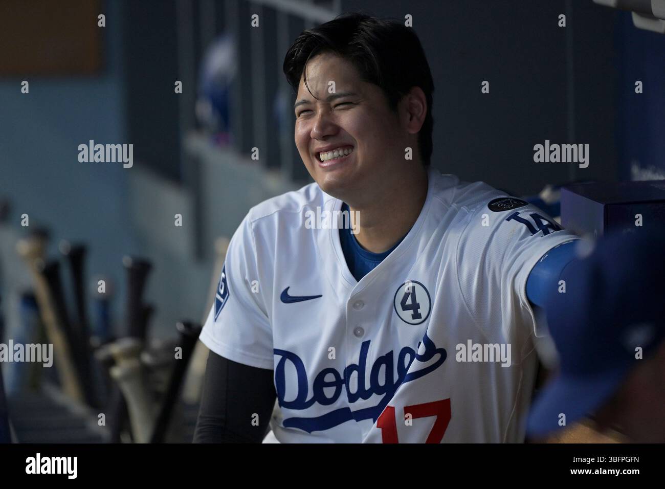 Los Angeles Dodgers' Shohei Ohtani smiles in the dugout during the ...