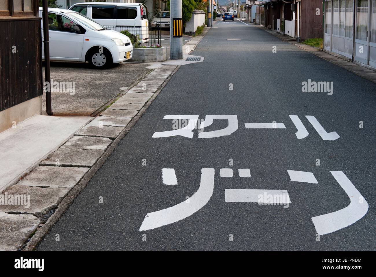 Japanese katakana script written on the roadway warns drivers of a ...