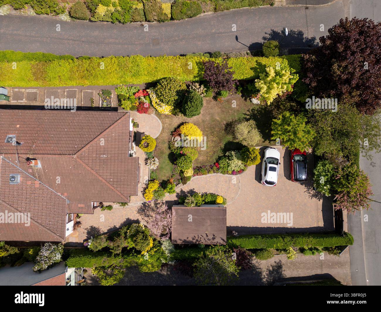 Overhead aerial view of a house, front garden and driveway parking with ...
