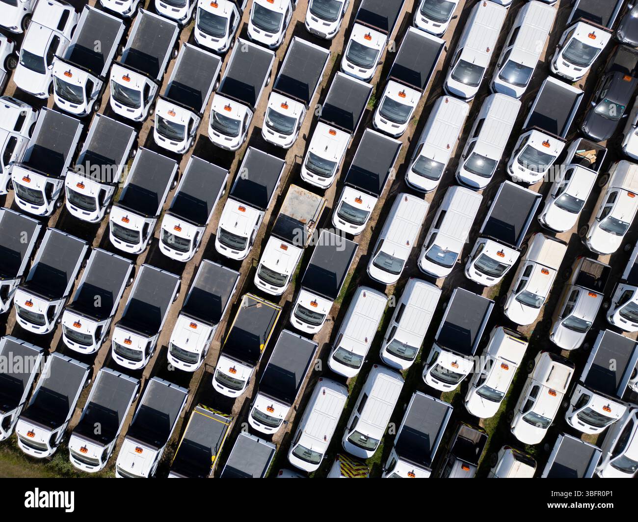 Aerial view of new flatbed trucks ad vans in rows, England Stock Photo ...