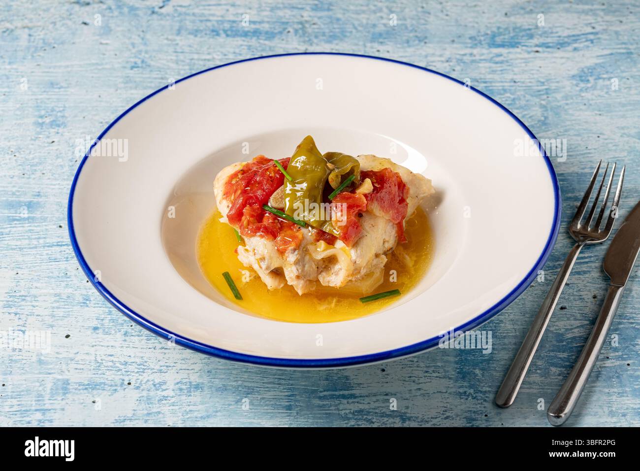 Steamed sea bass in a white porcelain plate on a blue stone table Stock ...