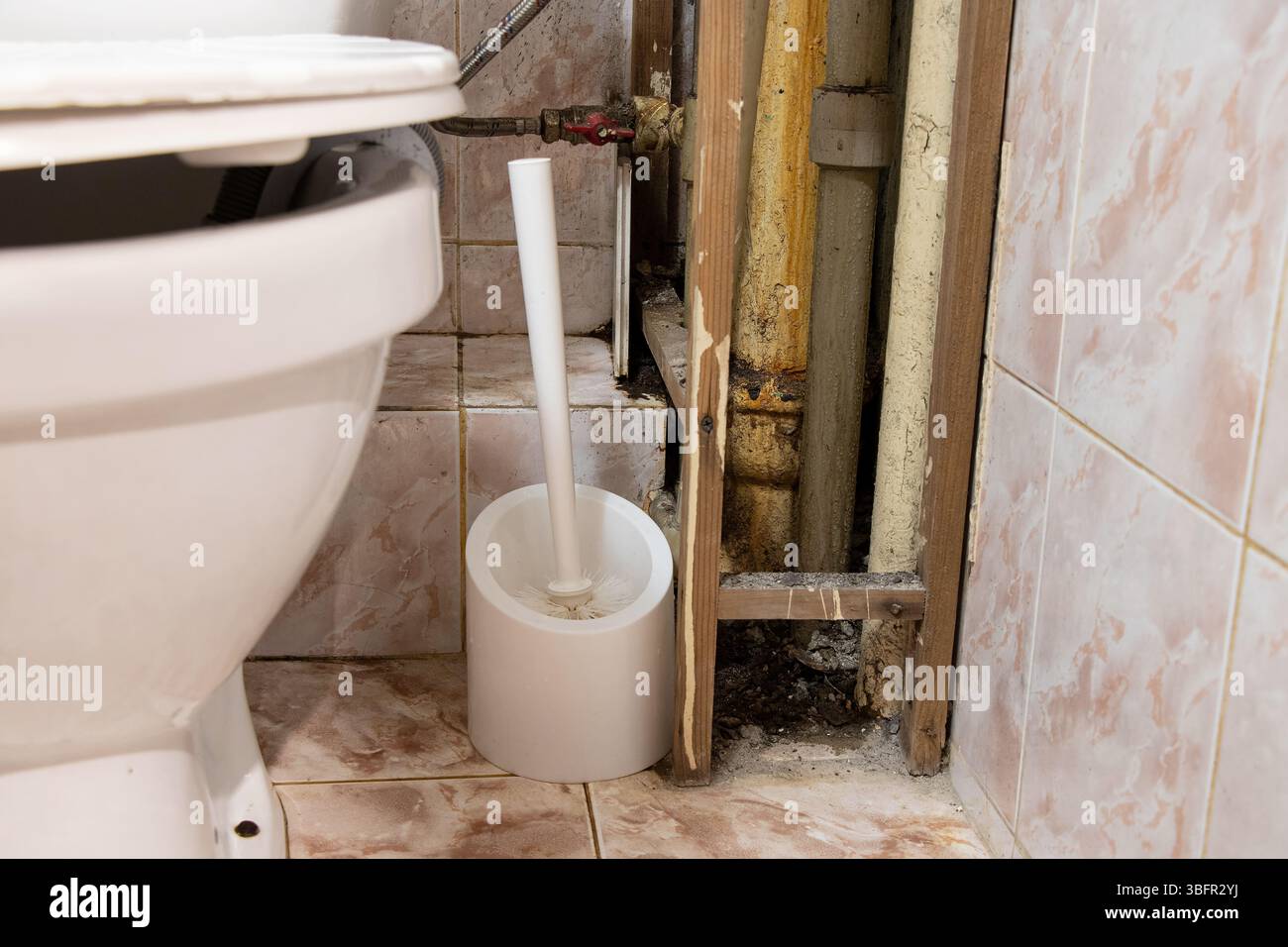 Old pipes with condensation and fungus in the toilet of an apartment ...