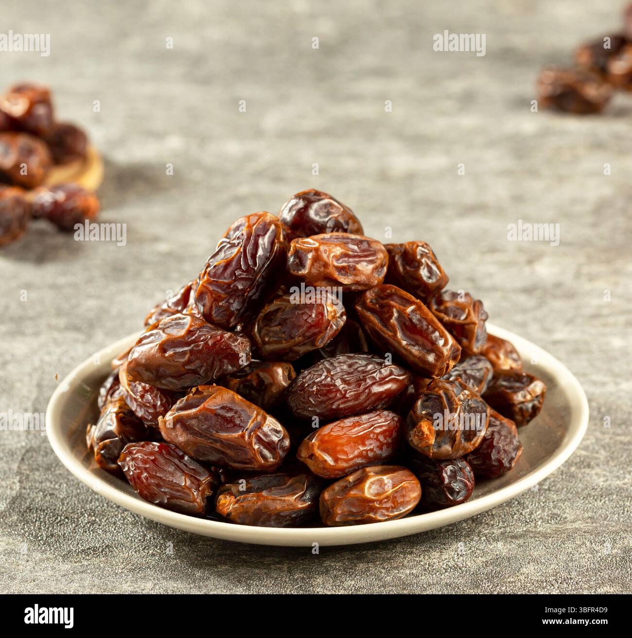 Ceramic plate filled with Medjool dates, large and soft fruits known ...
