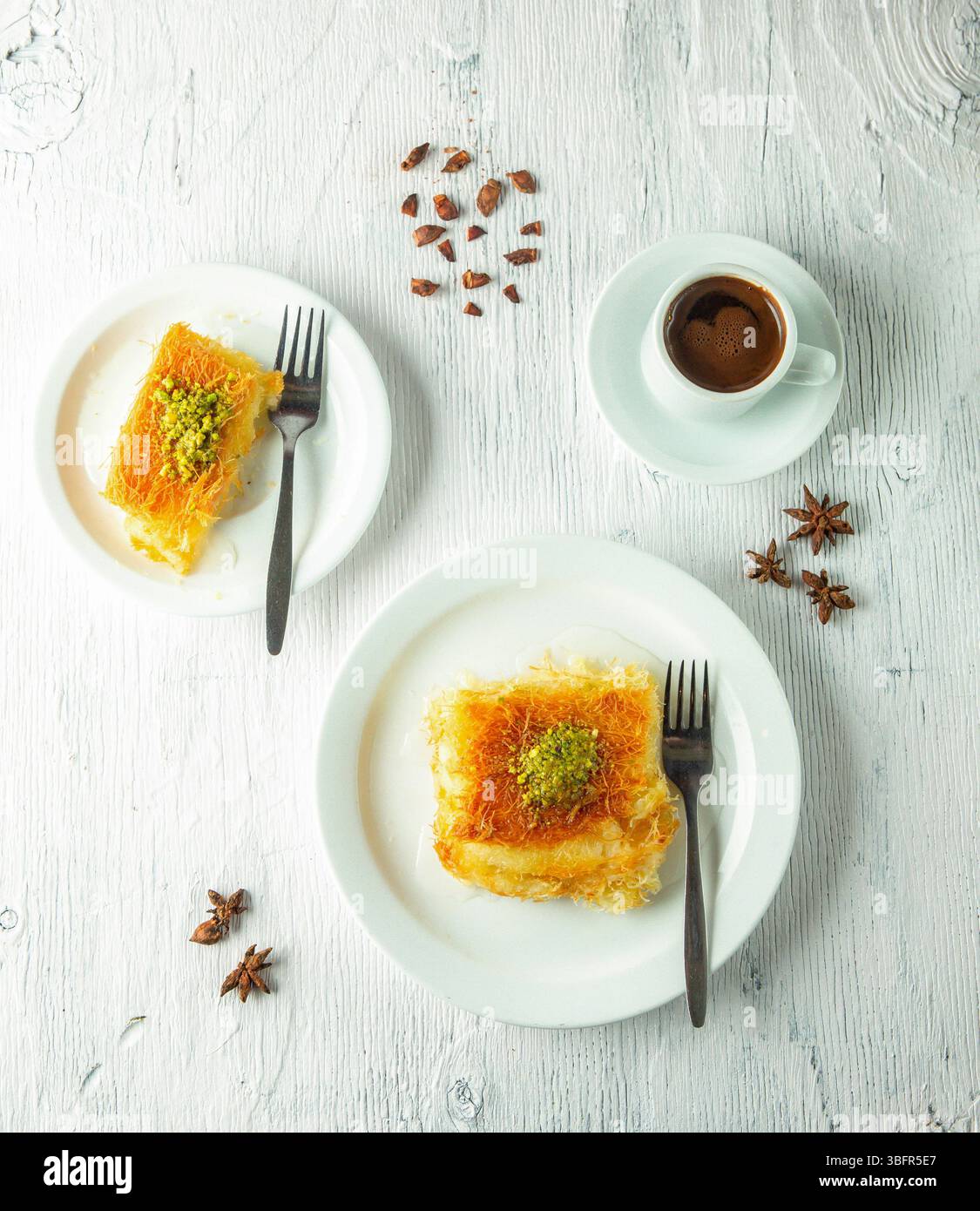 Flat lay of kunafa dessert with a cup of coffee, Turkish sweets on a ...