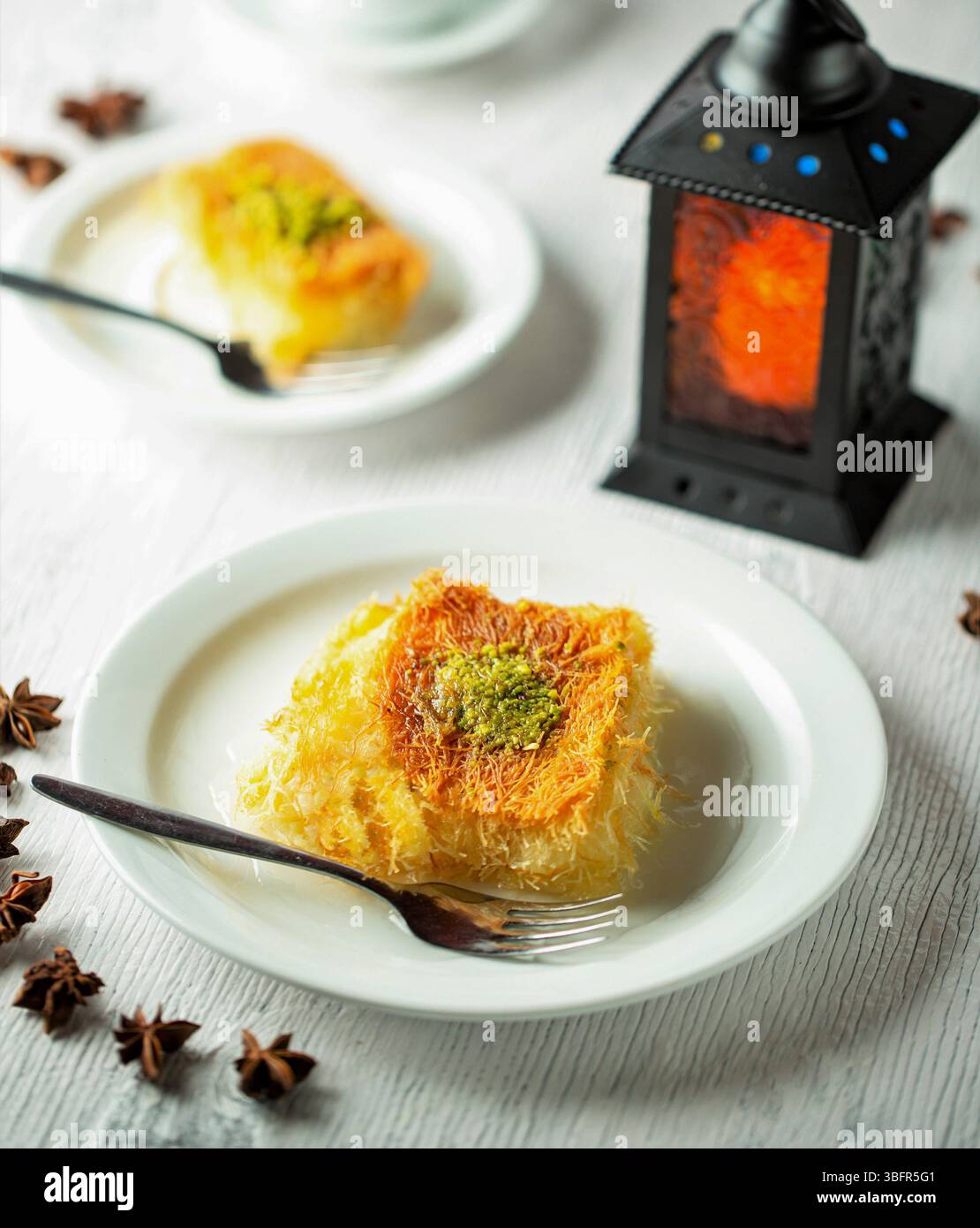 Kunafa with cream filling, Middle Eastern dessert on a white background with a decorative ...