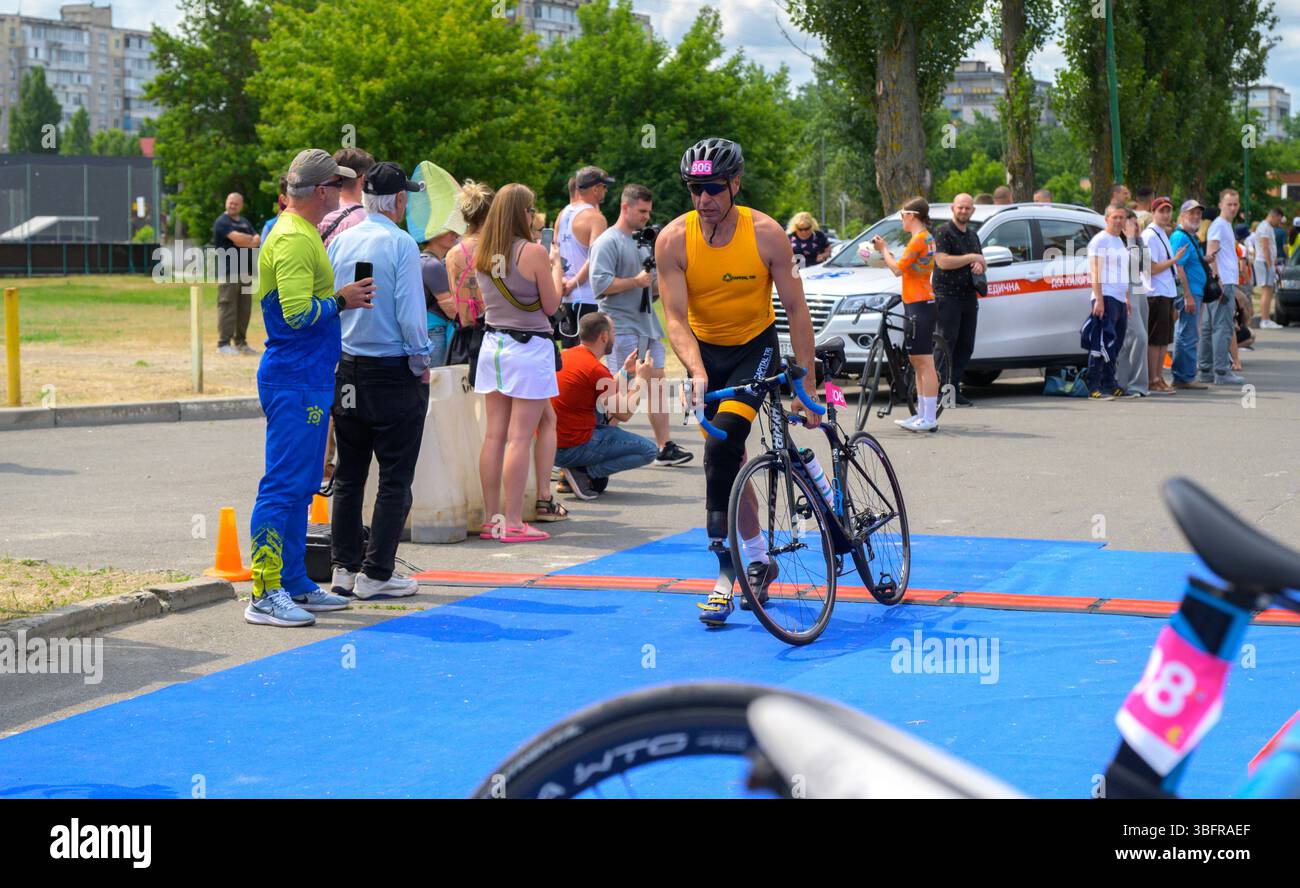 Kyiv, Ukraine - 1st June, 2025: Paratriathlete walking with his bicycle ...