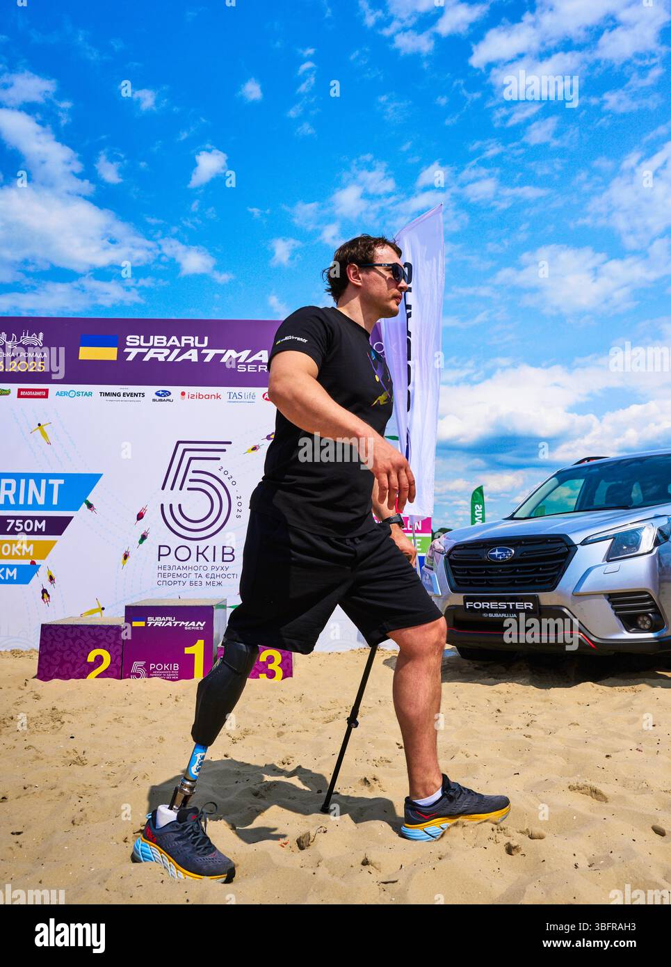 Kyiv, Ukraine - 1st June, 2025: Paratriathlete walking on the sand with ...