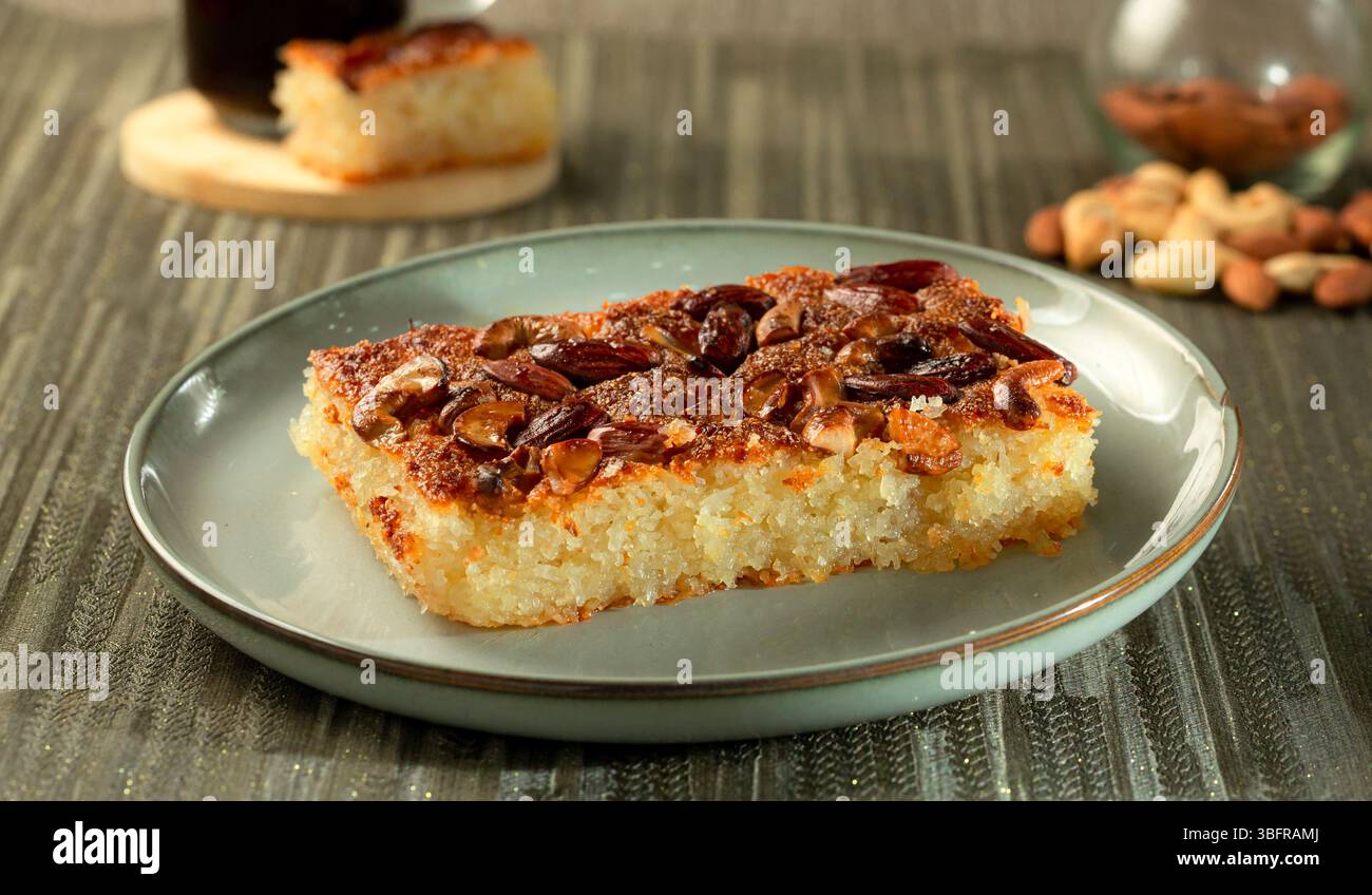 Plate of Basbousa topped with nuts, traditional semolina cake made with ...