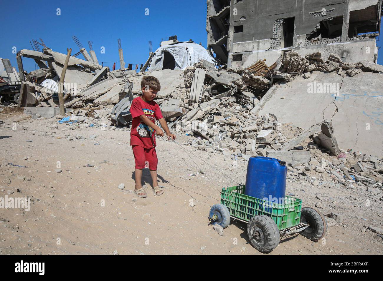 Palestinians carry jerry cans filled with water distributed by a water ...