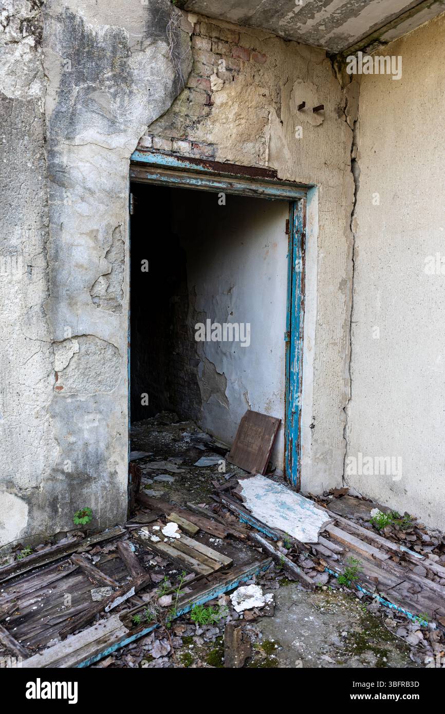 Decayed entrance to a derelict building with broken wooden debris ...