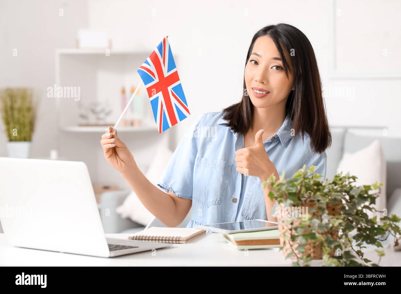 Beautiful Asian woman with UK flag learning English language online at ...