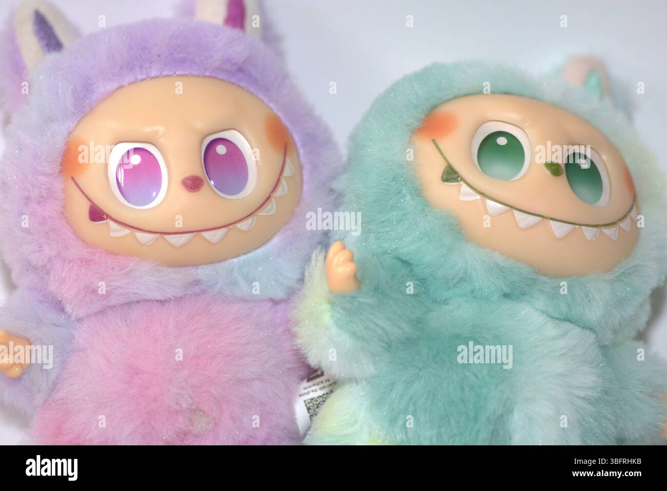 Two playful Labubu toy figures in a fluffy green and pink monster ...