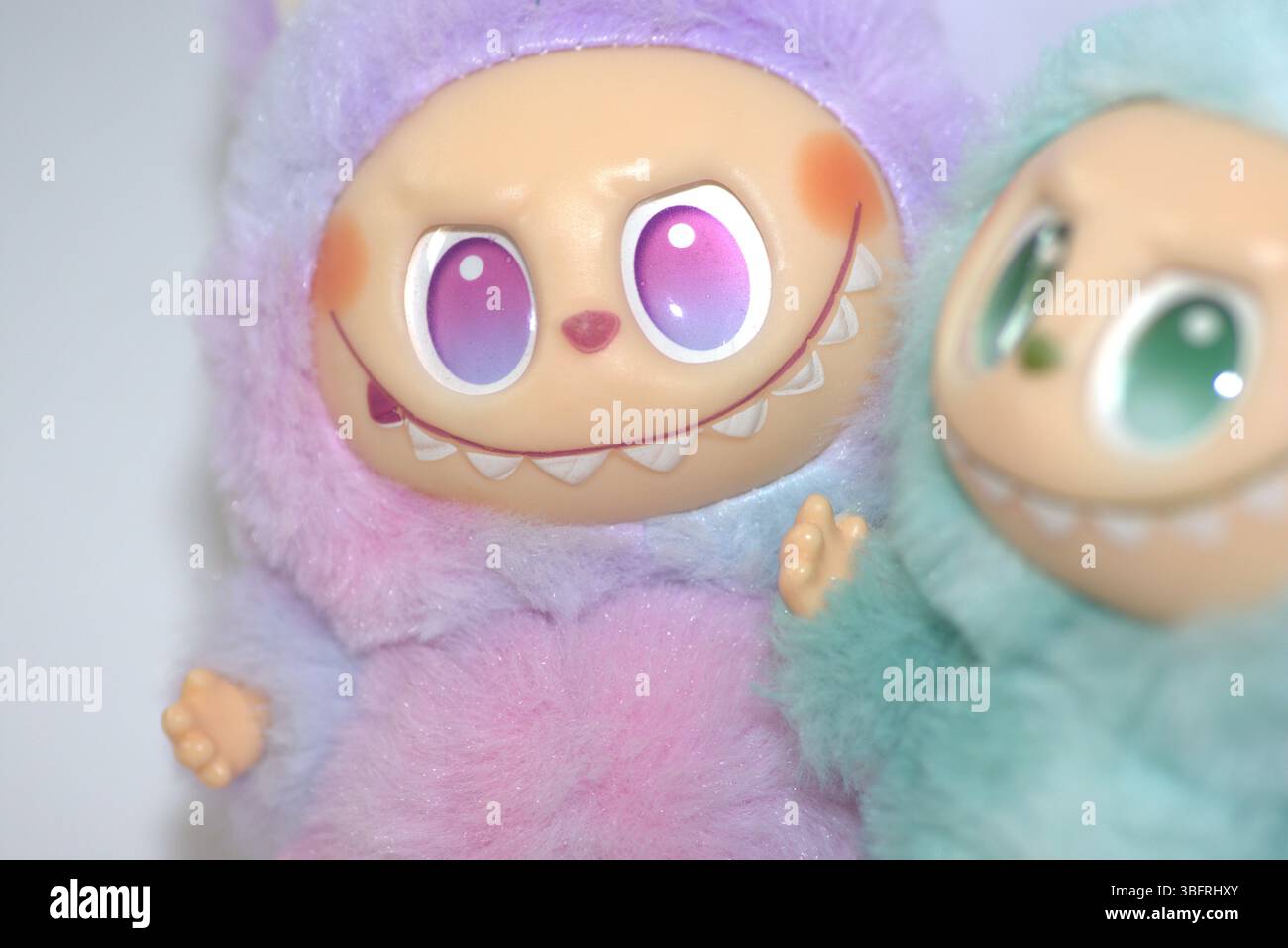 Two playful Labubu toy figures in a fluffy green and pink monster ...