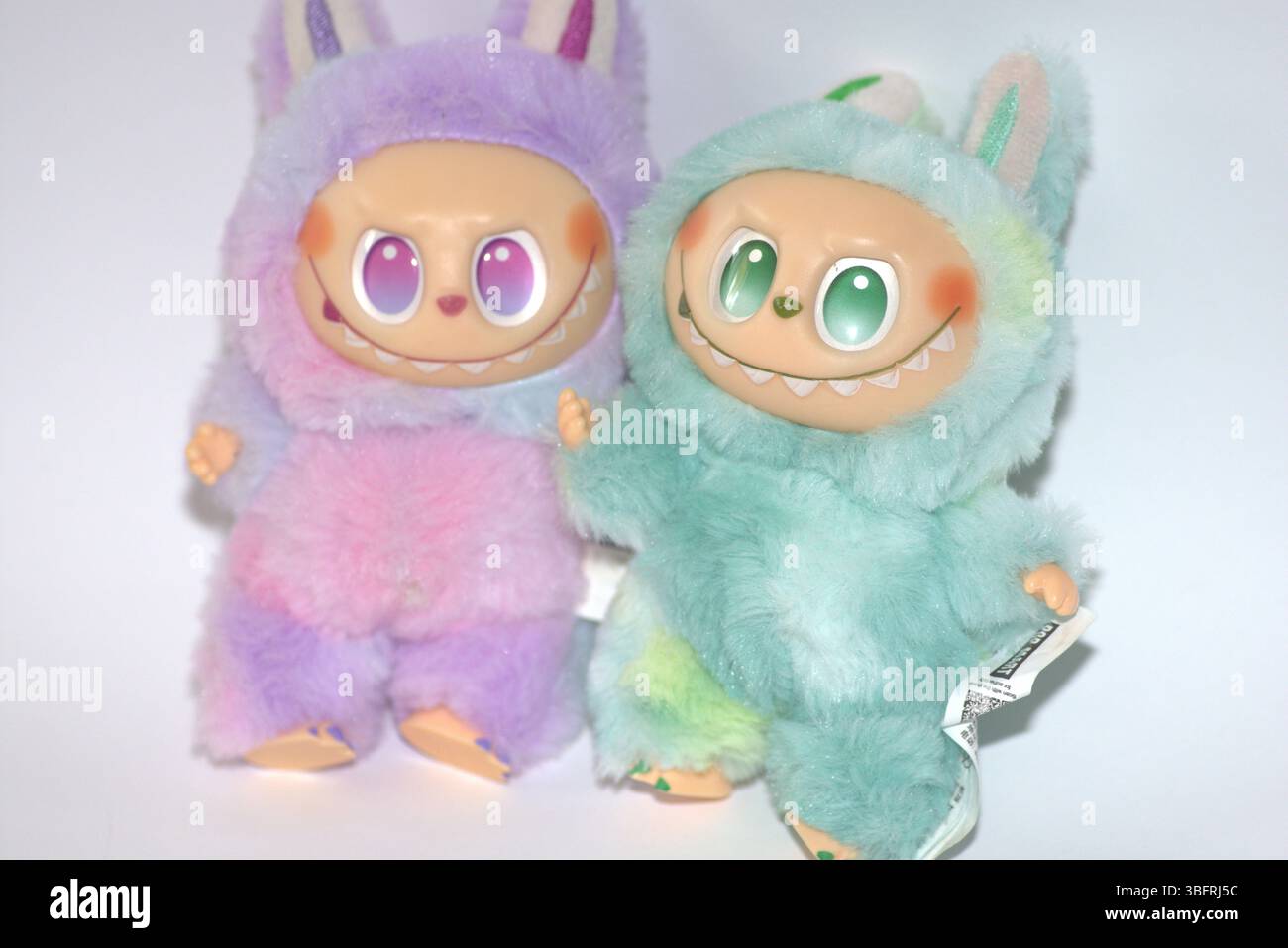 Two playful Labubu toy figures in a fluffy green and pink monster ...