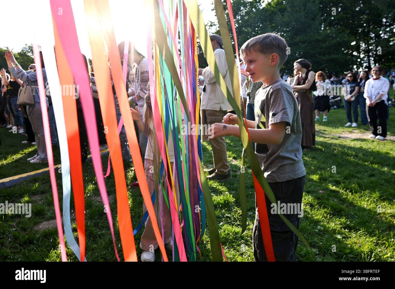 A boy stands by the colorful ribbons during the Chekafest festival in ...