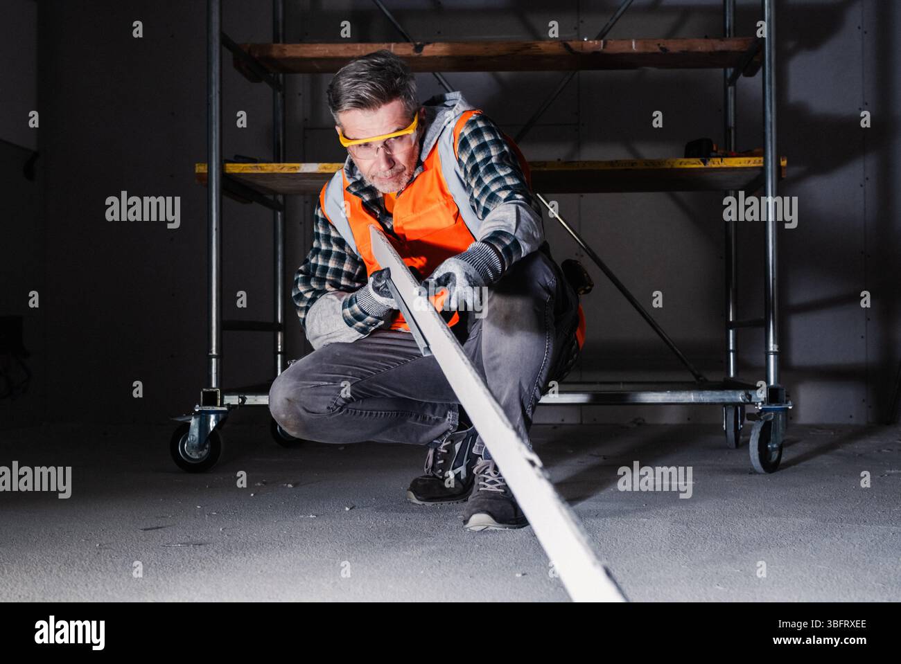 Construction professional working with focus while aligning a drywall ...