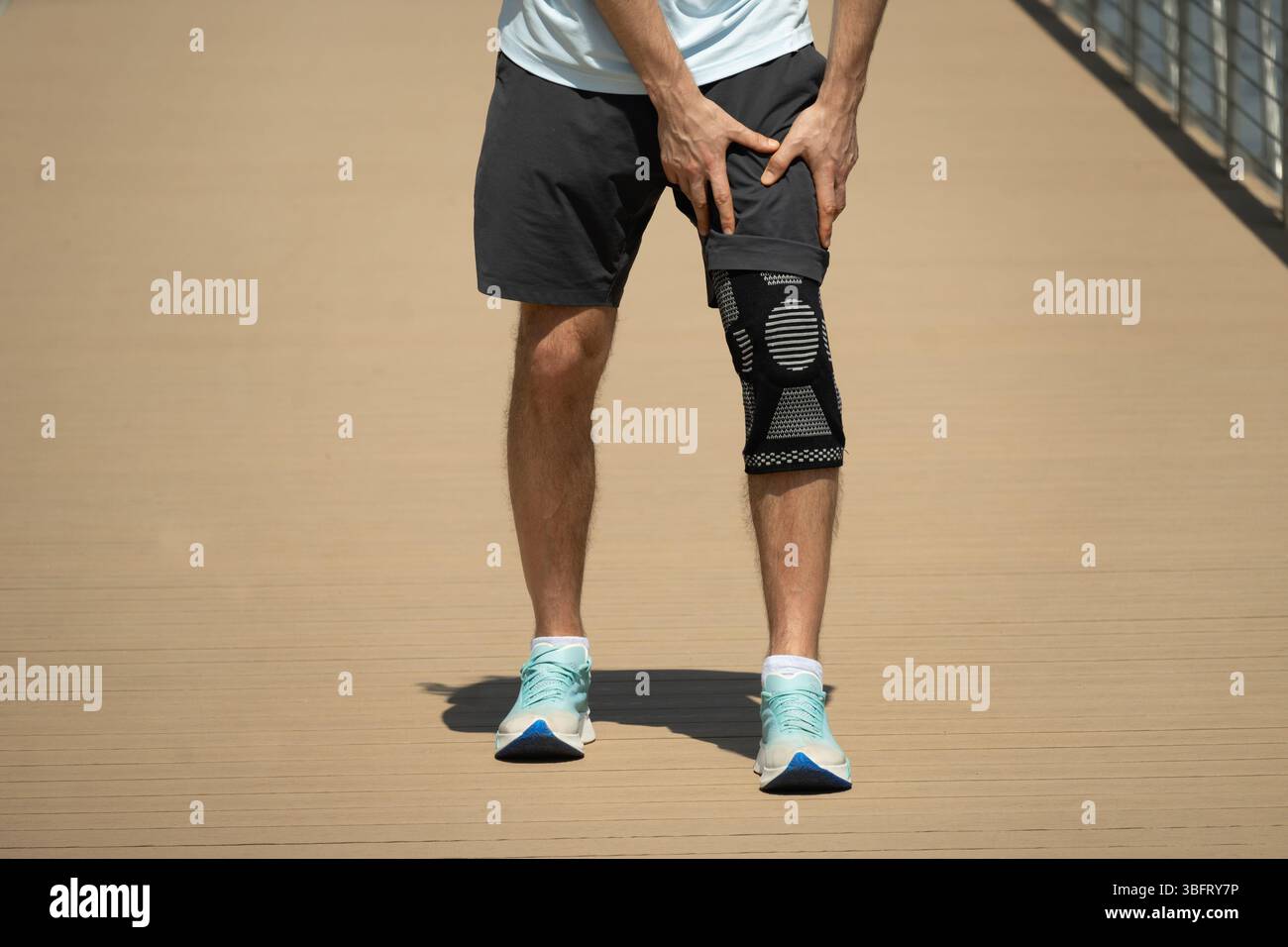 Man putting knee brace to support painful leg. Athlete bodybuilder leg ...