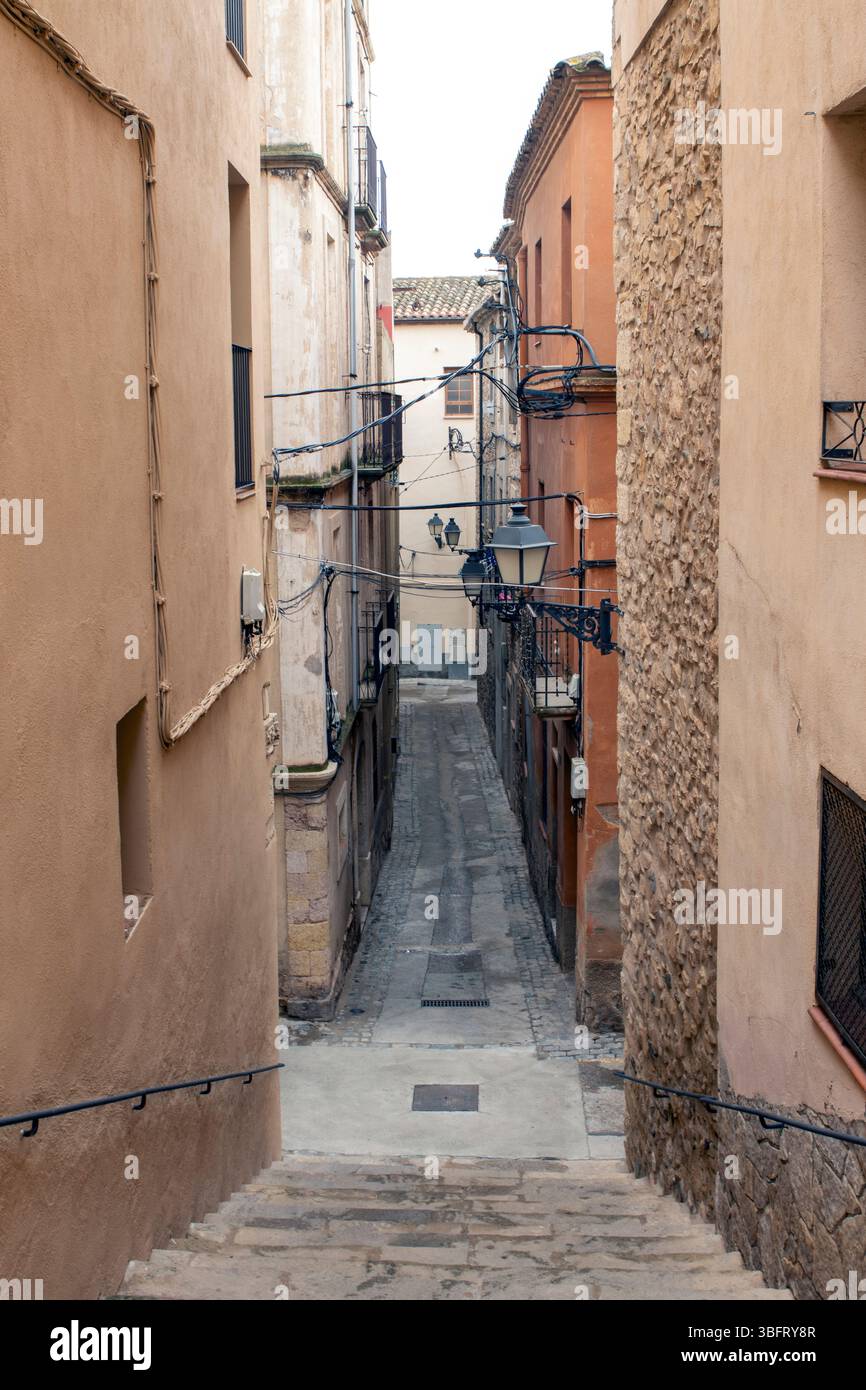 Historic Mediterranean alley with aged buildings, overhead wires, and ...