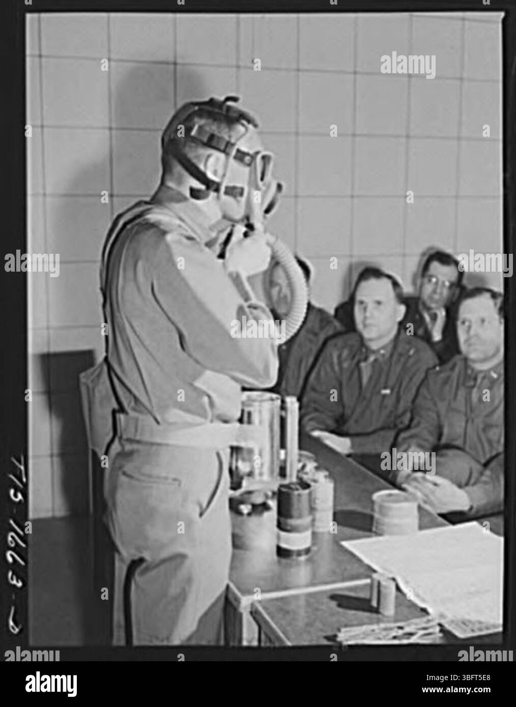 Captain William W. Kitchen is shown demonstrating gas mask usage to a ...