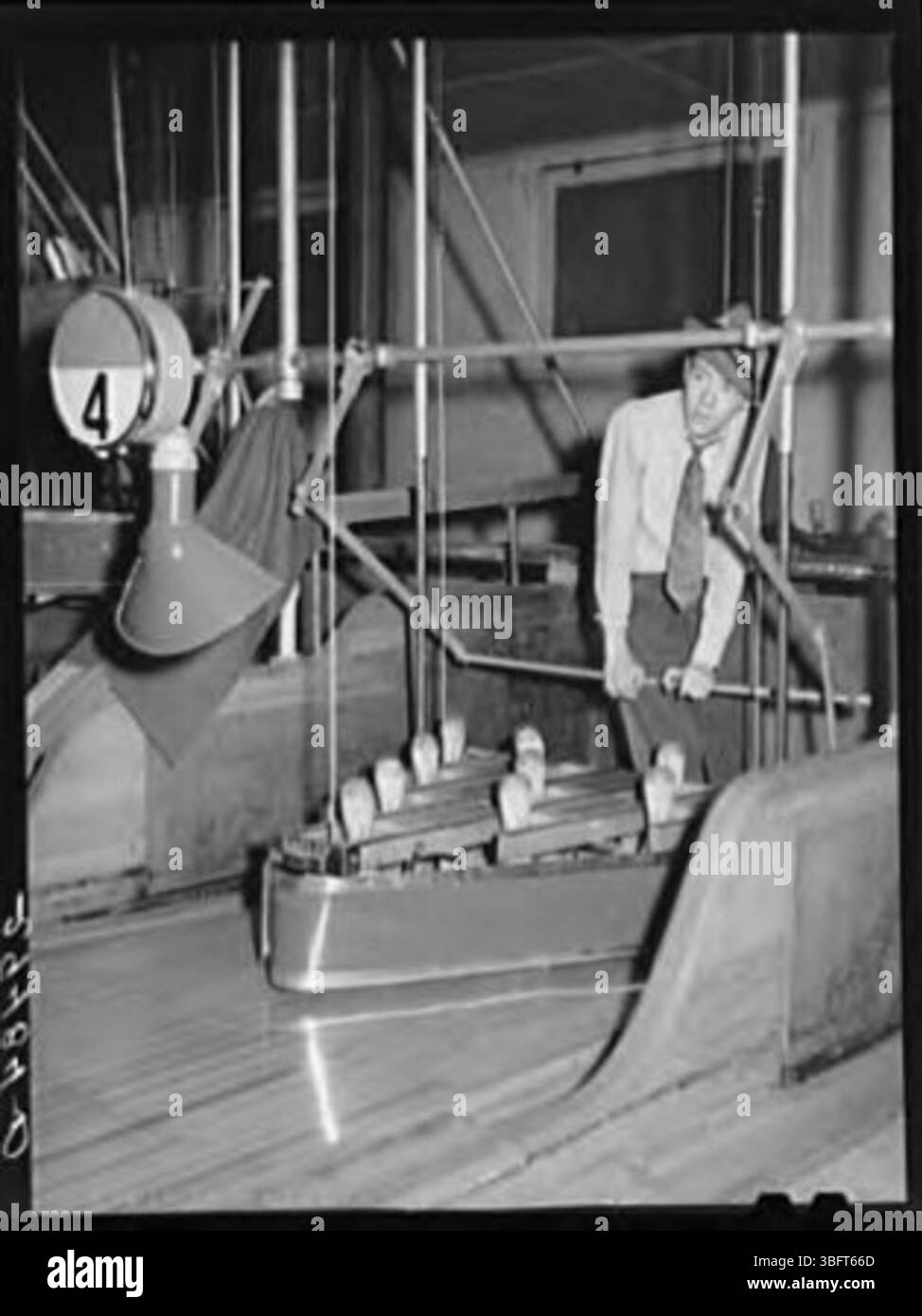 A pin boy at work in a bowling alley, illustrating the historical role ...