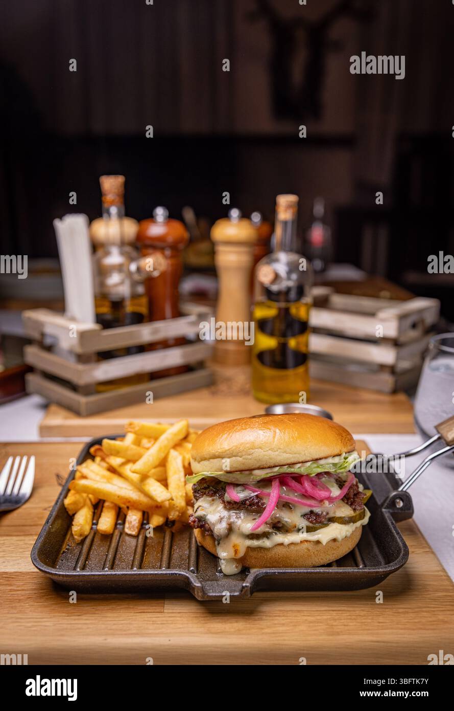 Delicious burger with french fries served on hot plate in restaurant ...