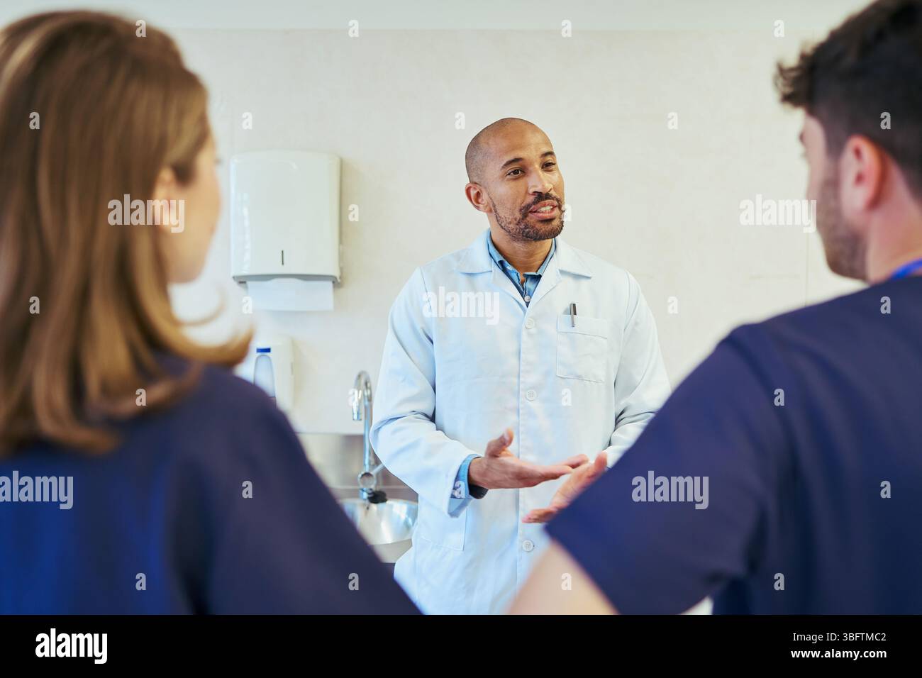 Doctor explaining medical procedure to nurses in hospital room Stock ...