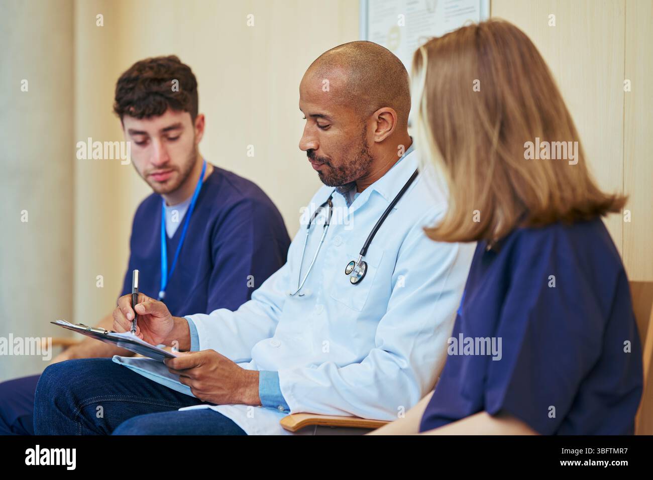 Medical team collaborating: doctor and nurses discussing patient chart ...