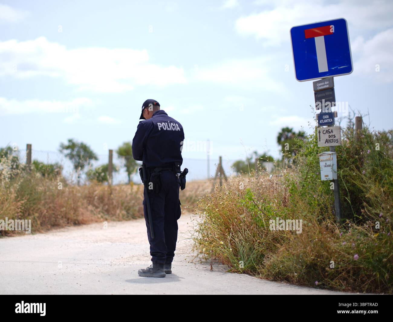 A Portuguese police officer patrols the entrance to a road close to ...
