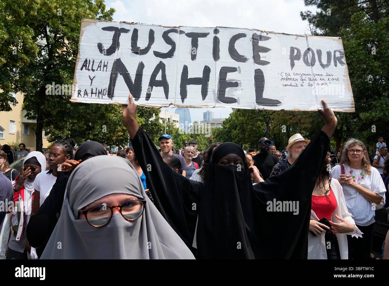 FILE - A woman shows a poster "Justice for Nahel" during a march for 17 ...