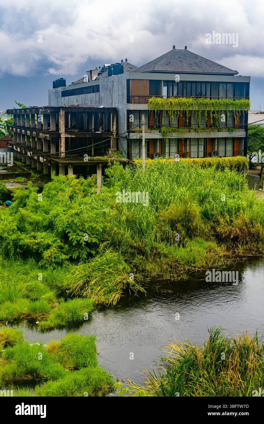 Large building with a green roof sits in front of a lush green forest ...
