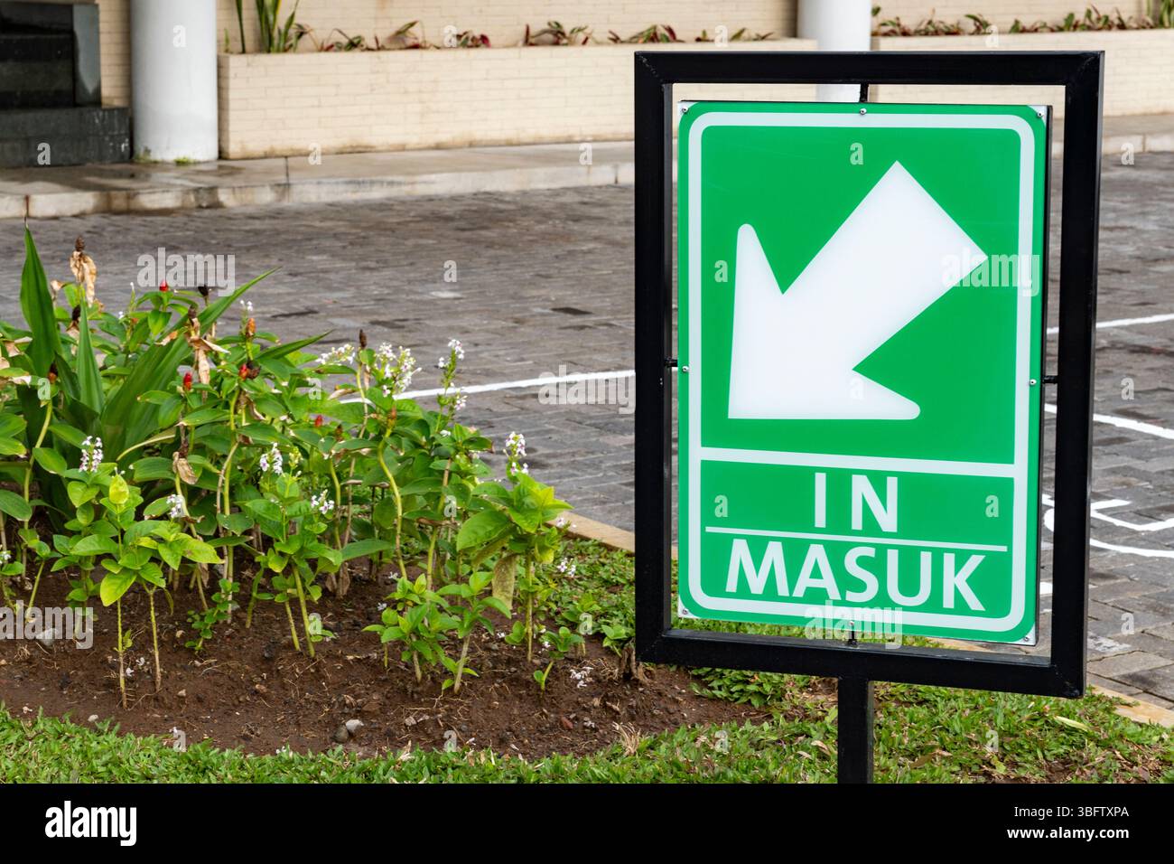 Green enter sign in the car park on the side of the road in English and ...