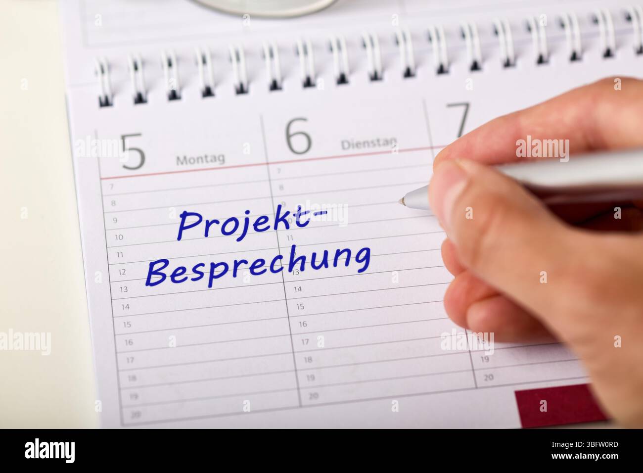 A hand-held calendar entry shows the handwritten note Projekt ...