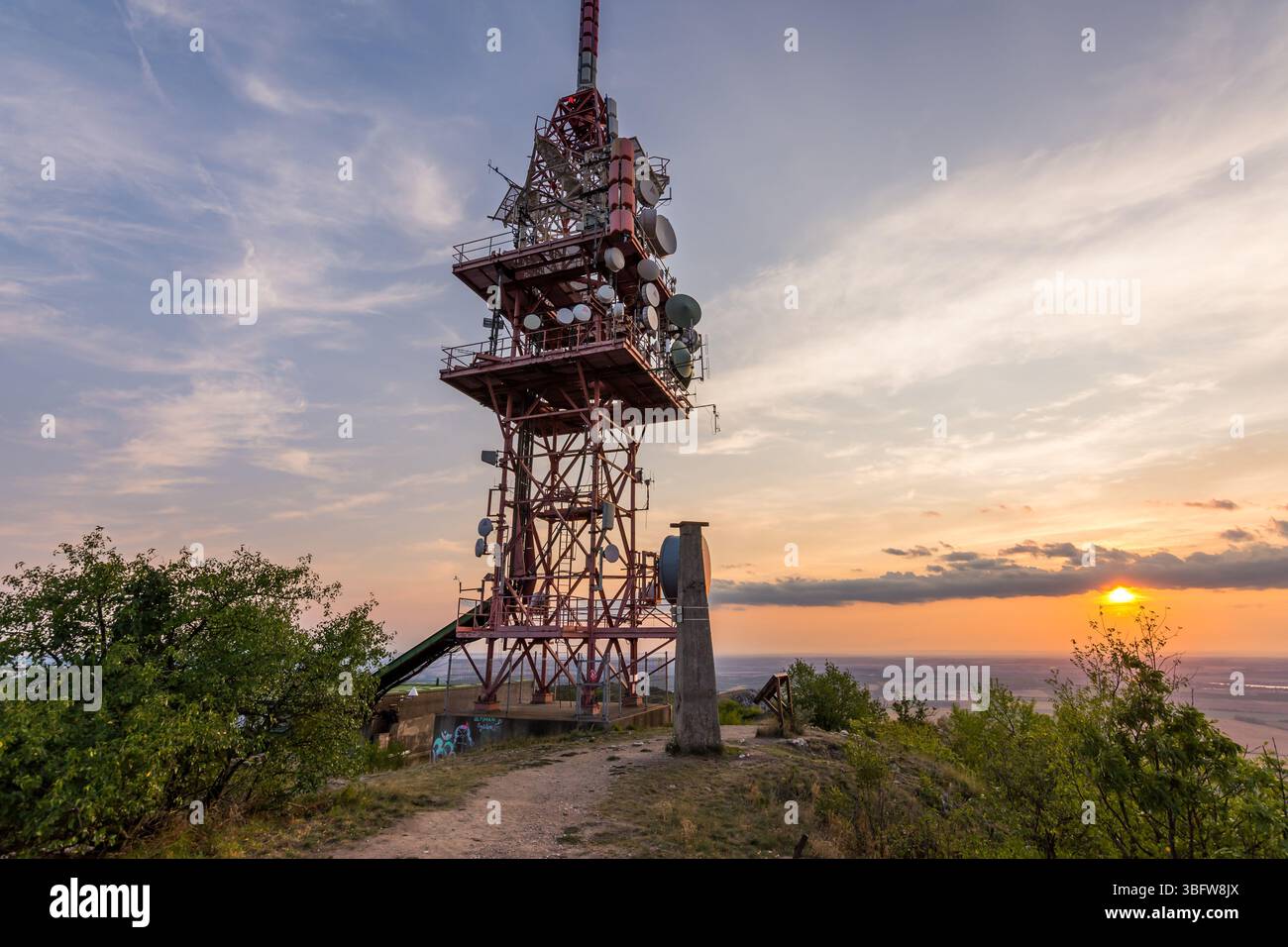 Transmitter tower antenna during the sunset on small hill Stock Photo ...