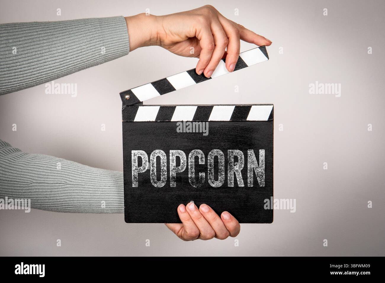 Popcorn - word on clapperboard held in hands, Cinema an entertainment ...